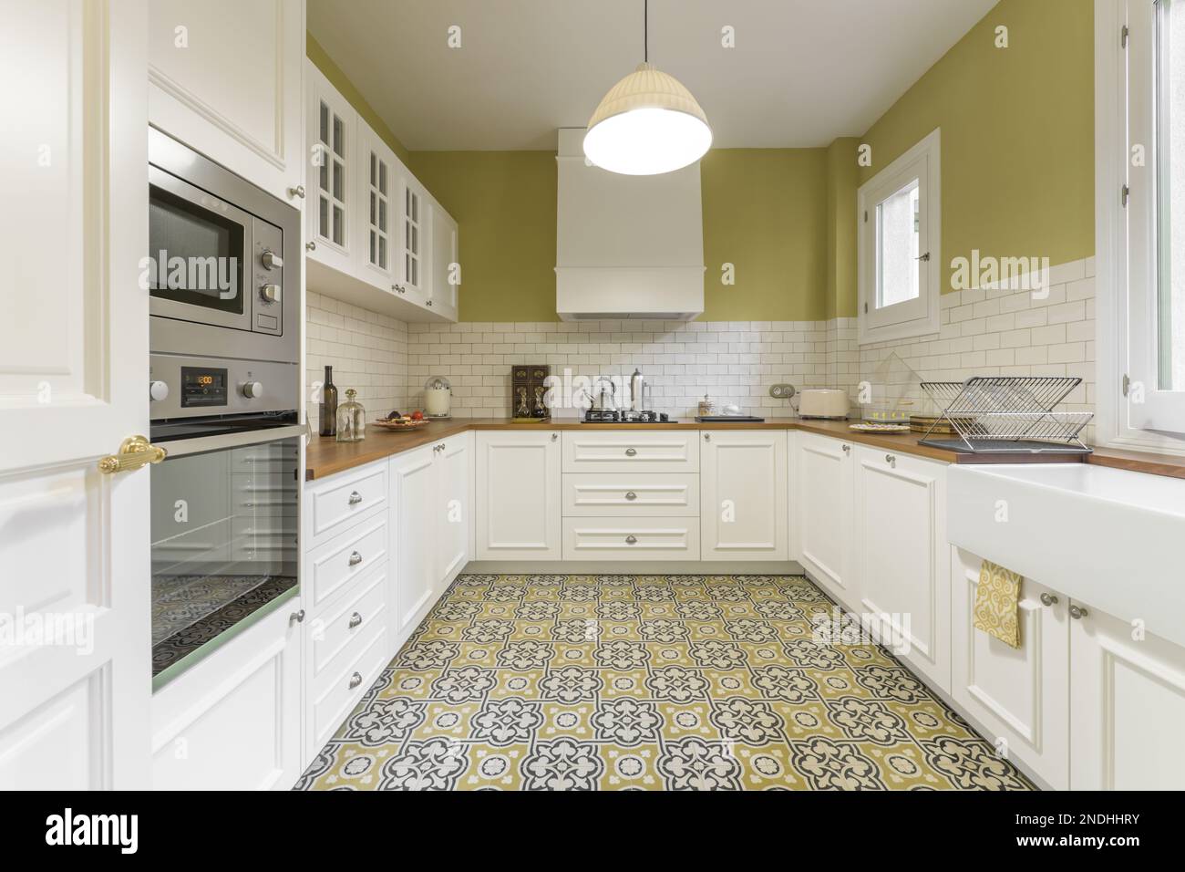 Vintage-style kitchen furnished in a u-shaped white lacquered wood with ...
