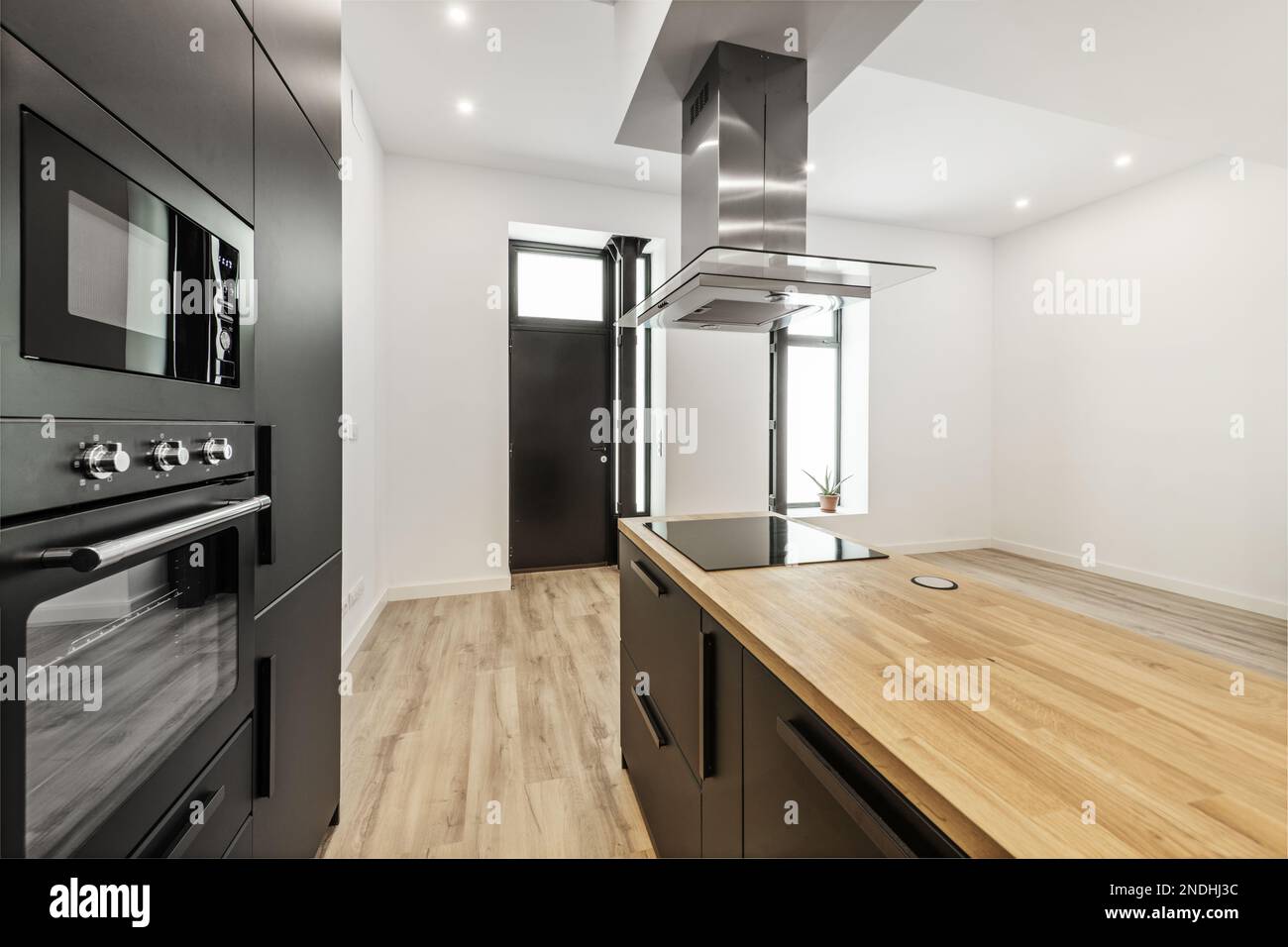 studio with an open kitchen with an island with black furniture, a ...