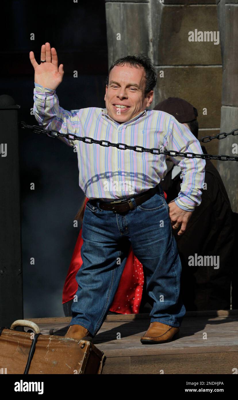 Actor Warwick Davis waves to fans during grand opening ceremonies of ...