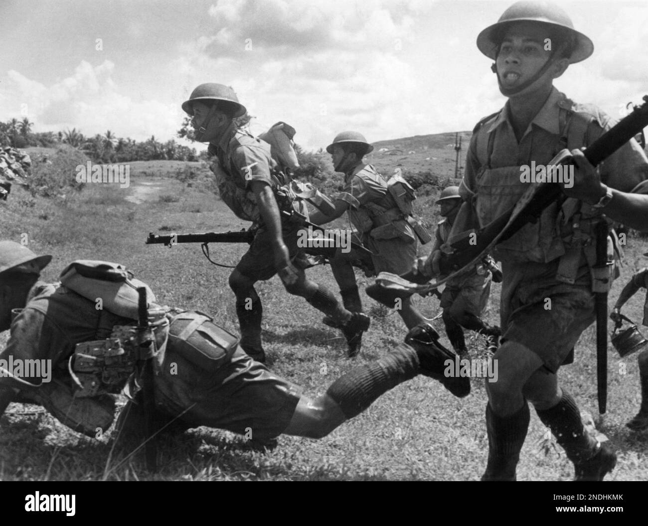 Malayan soldiers intent on defending their Peninsula charge forward ...