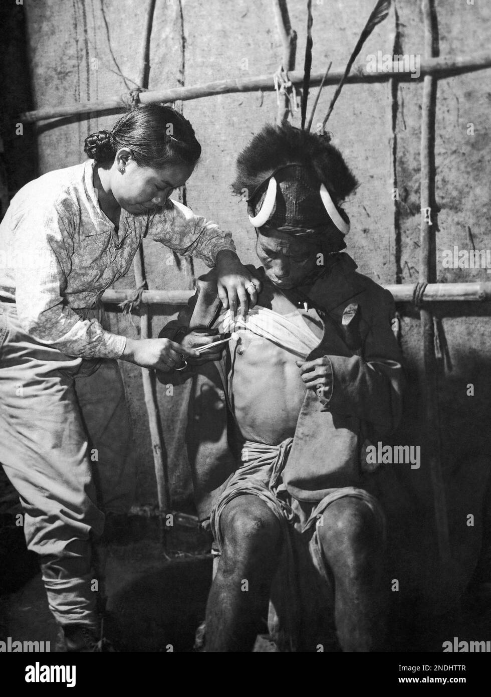 Roi Tsai treats infected leech bite for a Haga village headman, who ...