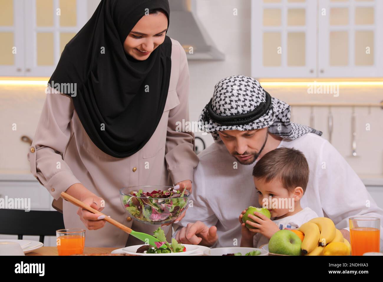 Happy Muslim family eating together in kitchen Stock Photo - Alamy