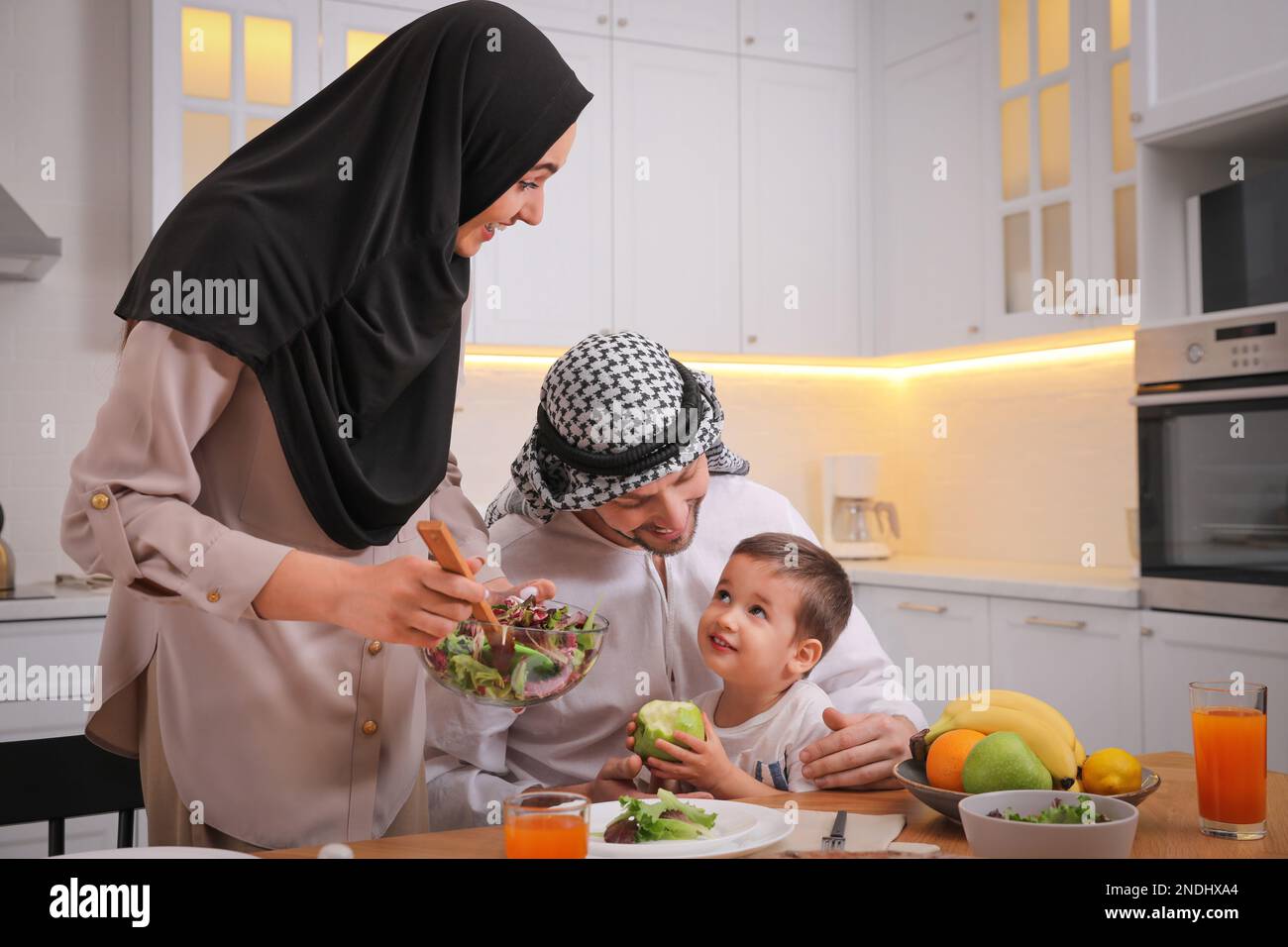 Happy Muslim family eating together in kitchen Stock Photo - Alamy