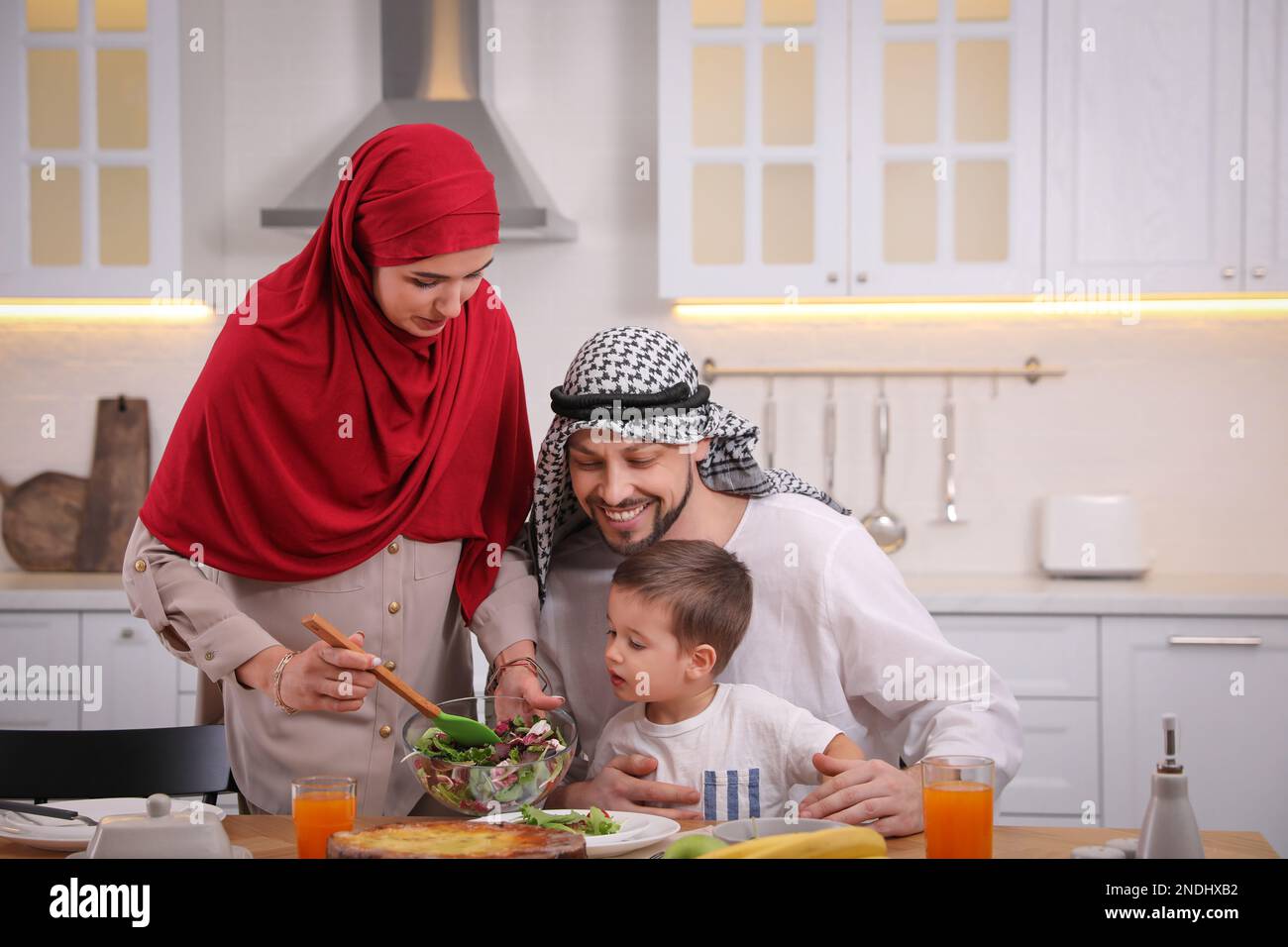 Happy Muslim family eating together in kitchen Stock Photo - Alamy