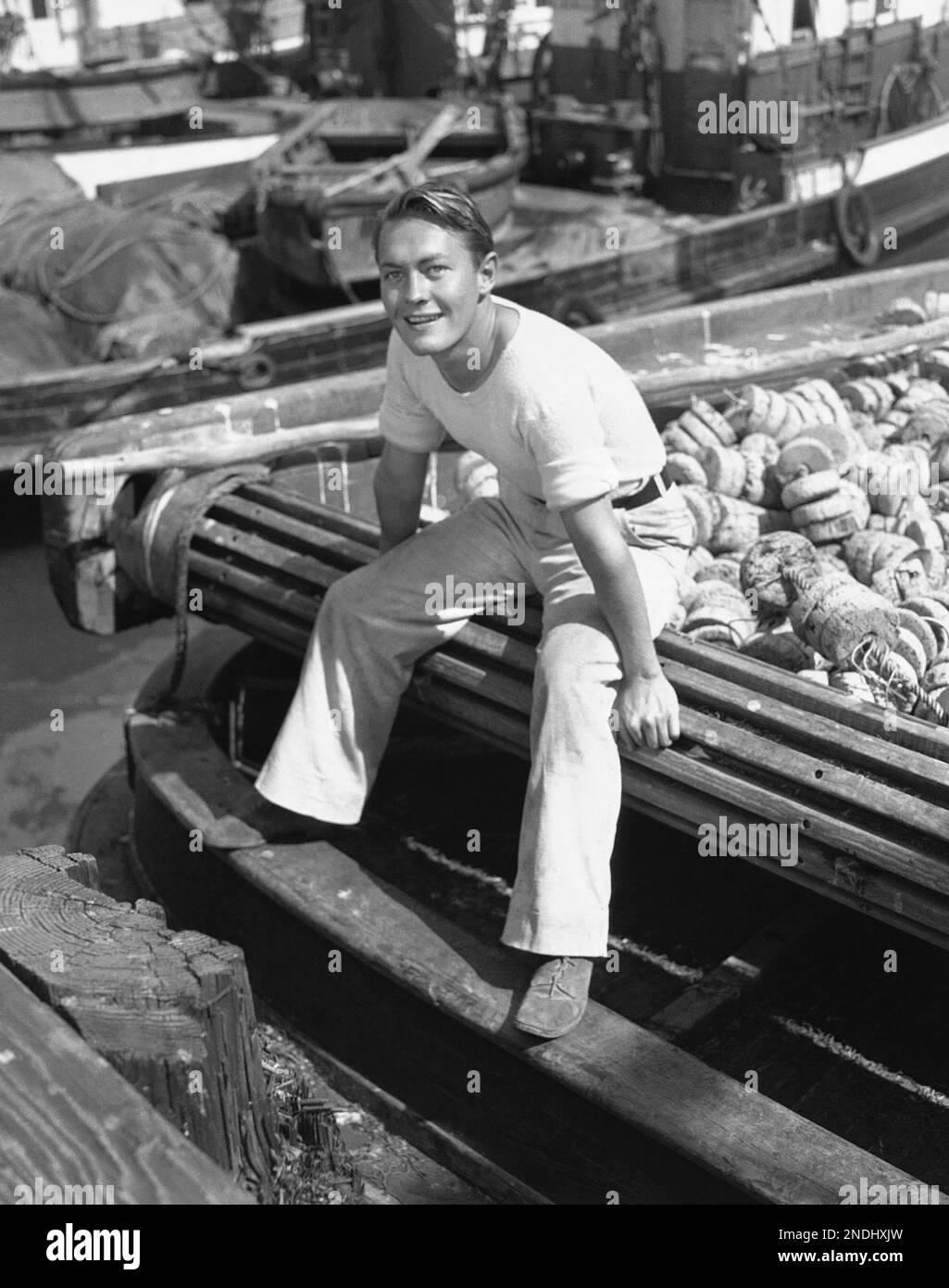 Richard Cromwell, film actor is shown here aboard a fishing boat at San ...