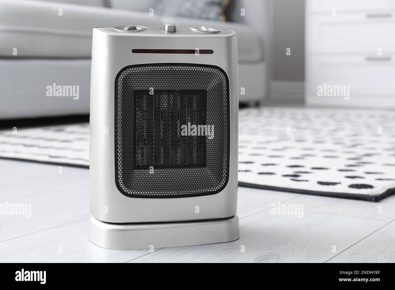 Modern electric fan heater on floor in living room Stock Photo - Alamy