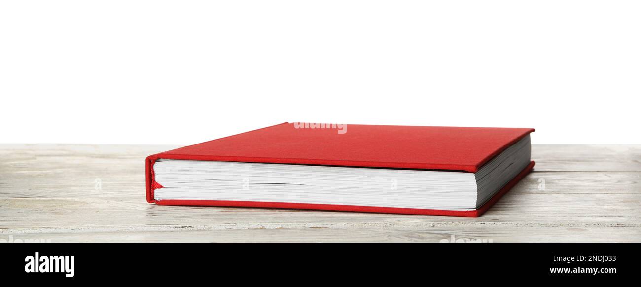 Book with red cover on wooden table against white background Stock ...