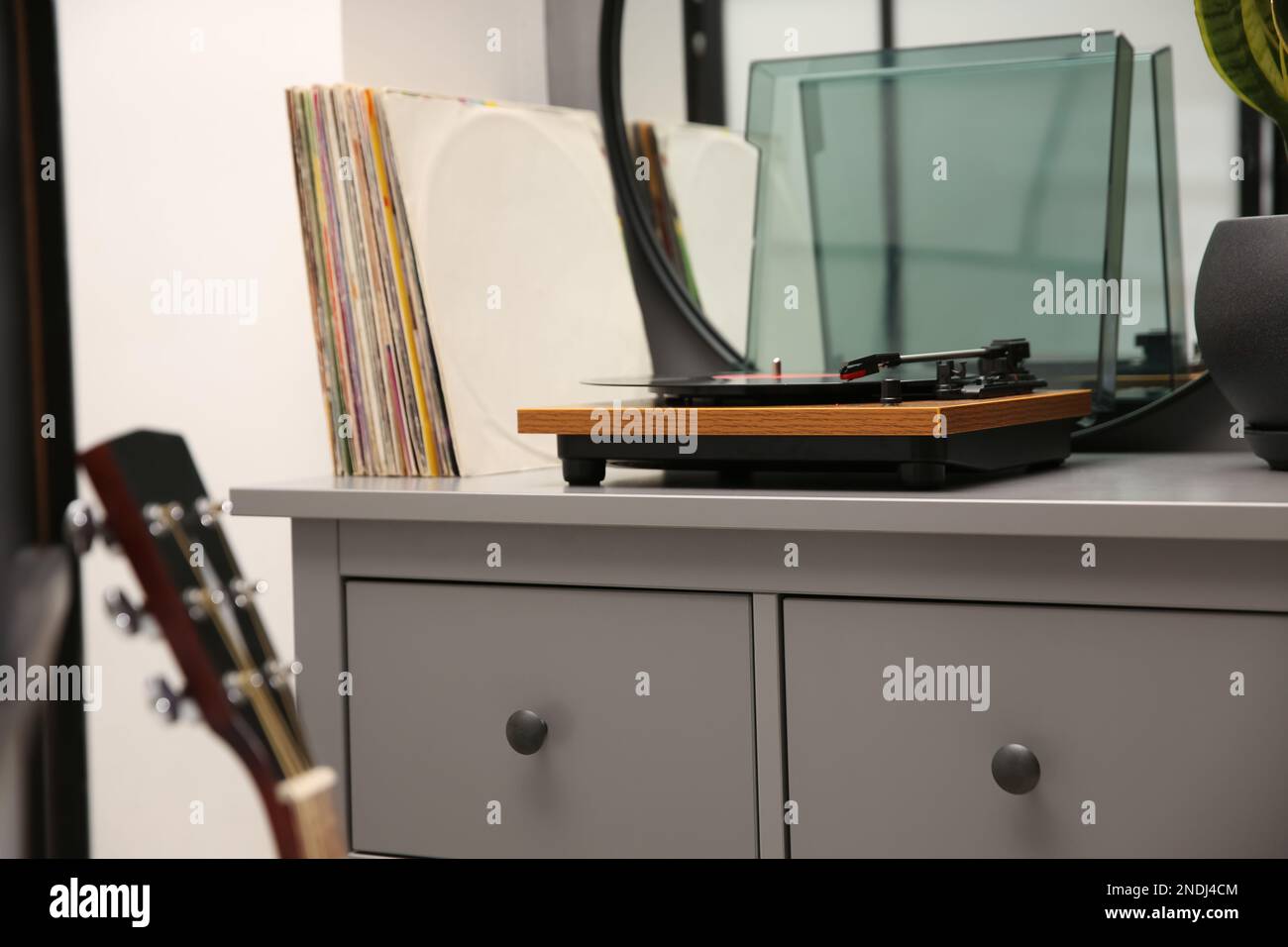 Stylish turntable with vinyl record on chest of drawers indoors Stock ...