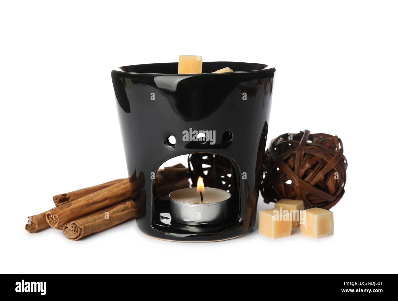 Stylish aroma lamp with essential wax cubes and cinnamon on white ...