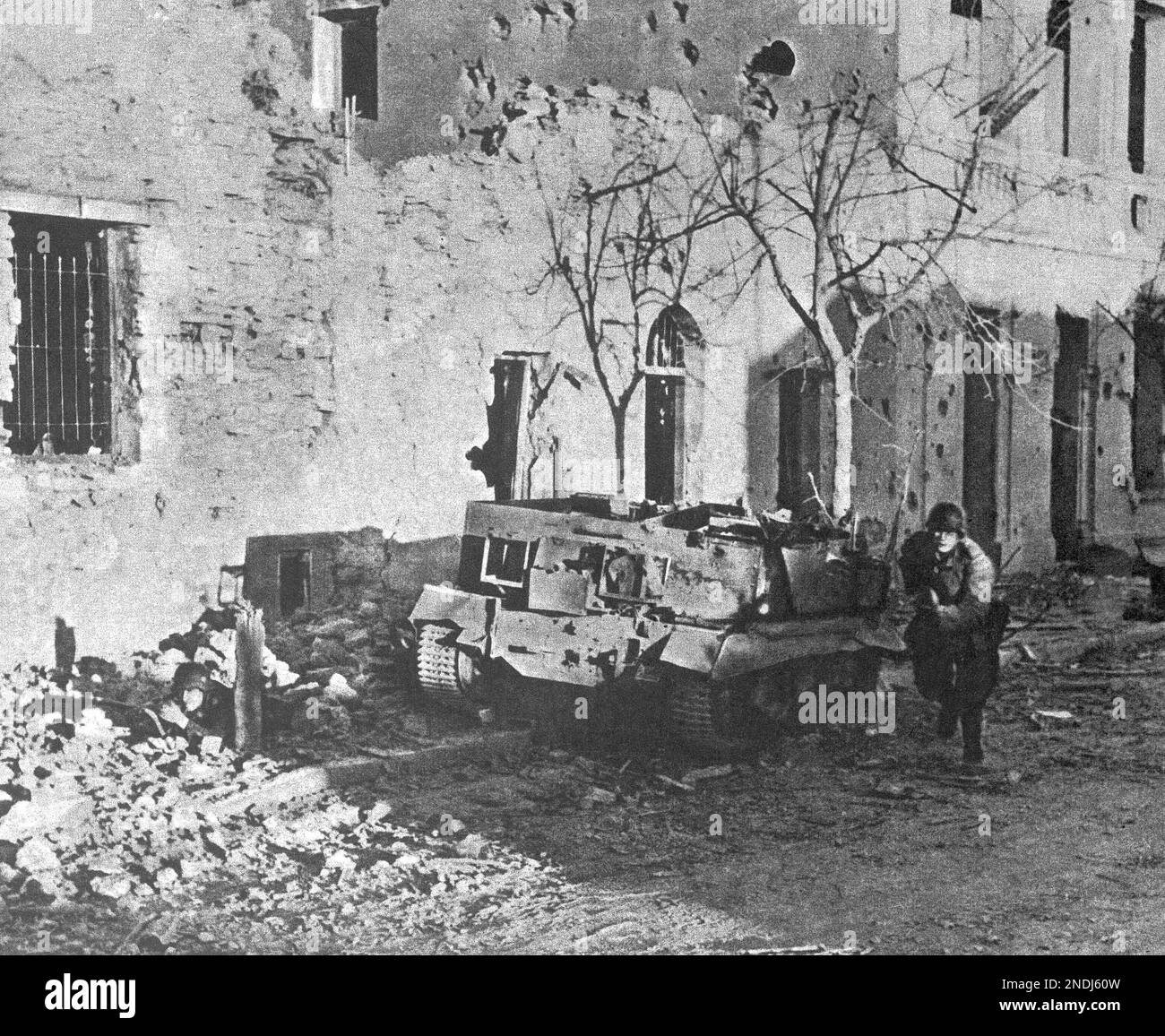 Following up a heavy barrage these Nazi infantrymen move into Tebourba ...