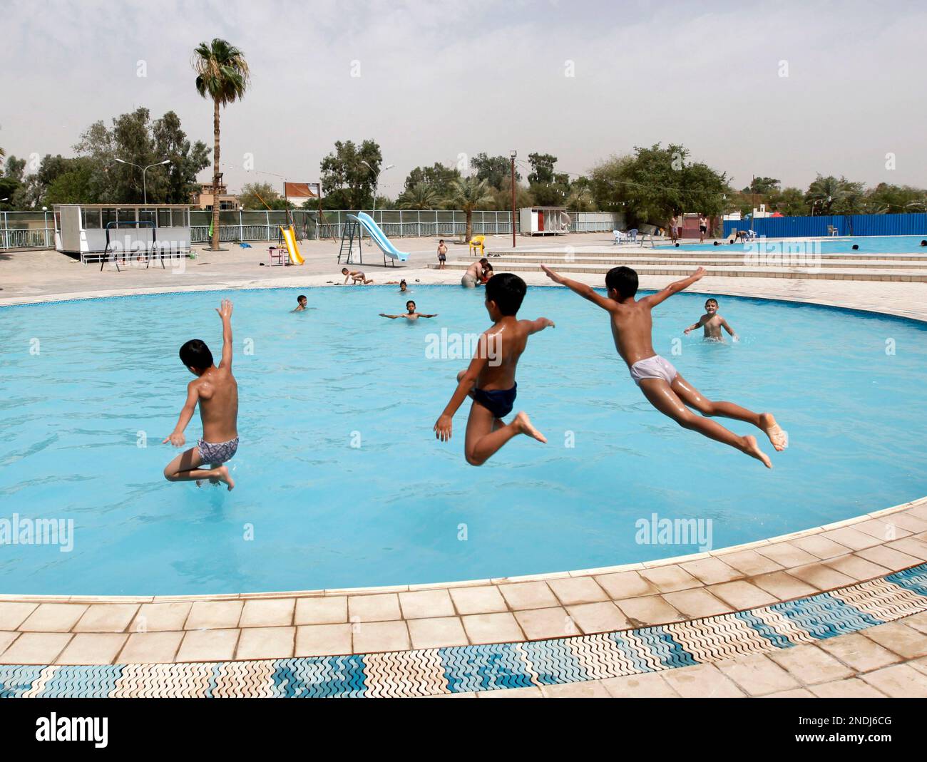 Boys leap into a public swimming pool in Baghdad, Iraq, Wednesday, June ...