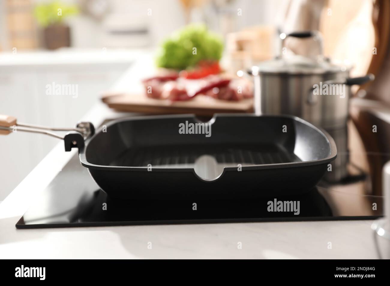 Frying pan with cooking oil on cooktop in kitchen Stock Photo - Alamy