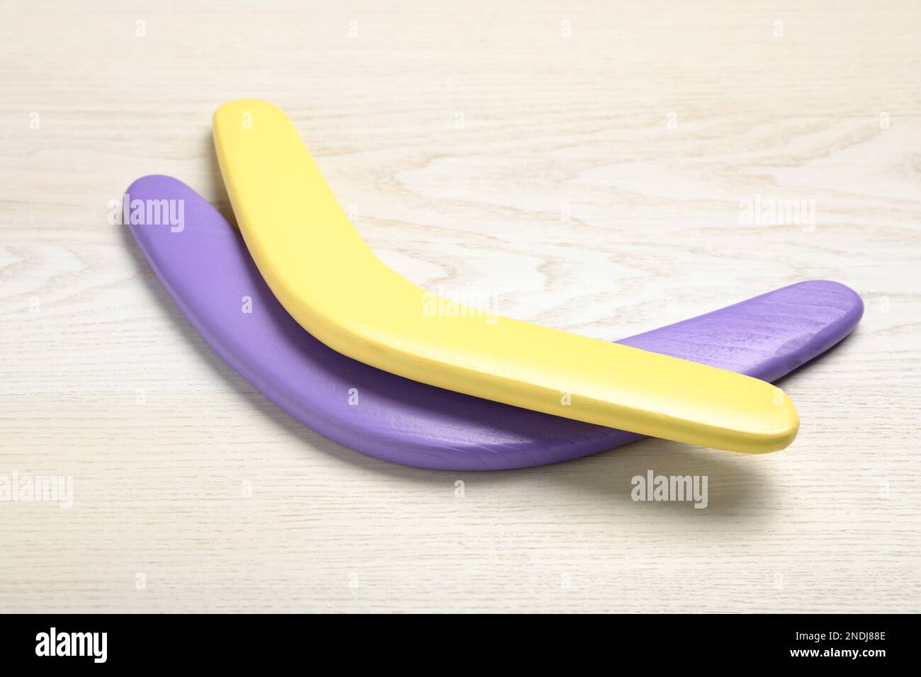 Color boomerangs on white wooden background. Outdoors activity Stock ...