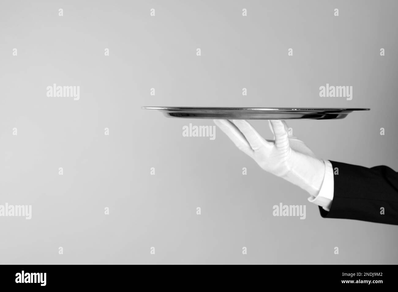 Butler with tray on light grey background, closeup. Space for text ...