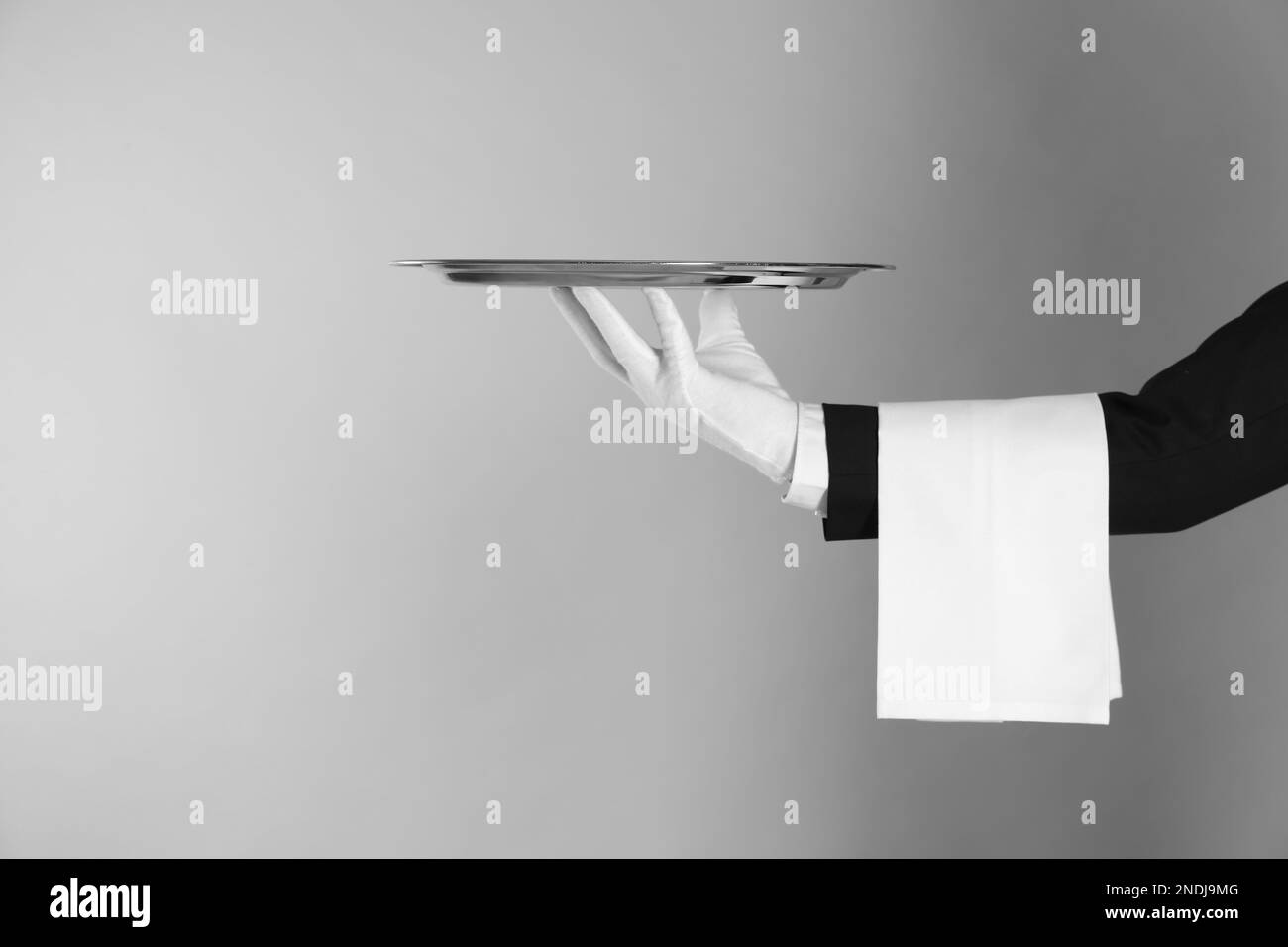 Butler with tray on light grey background, closeup. Space for text ...