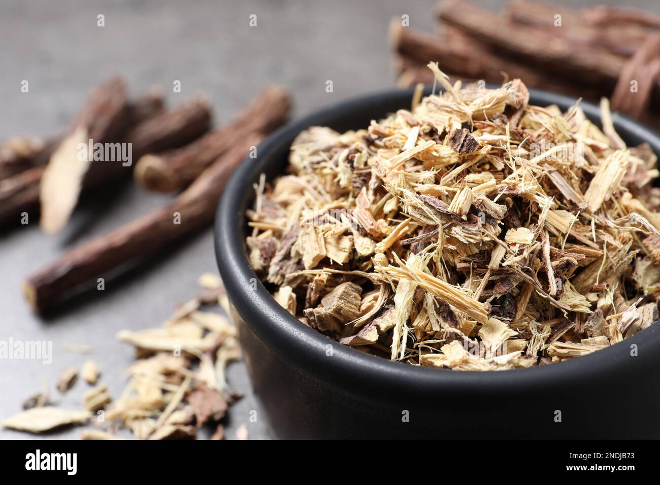 Dried sticks of liquorice root and shavings on grey table, closeup ...