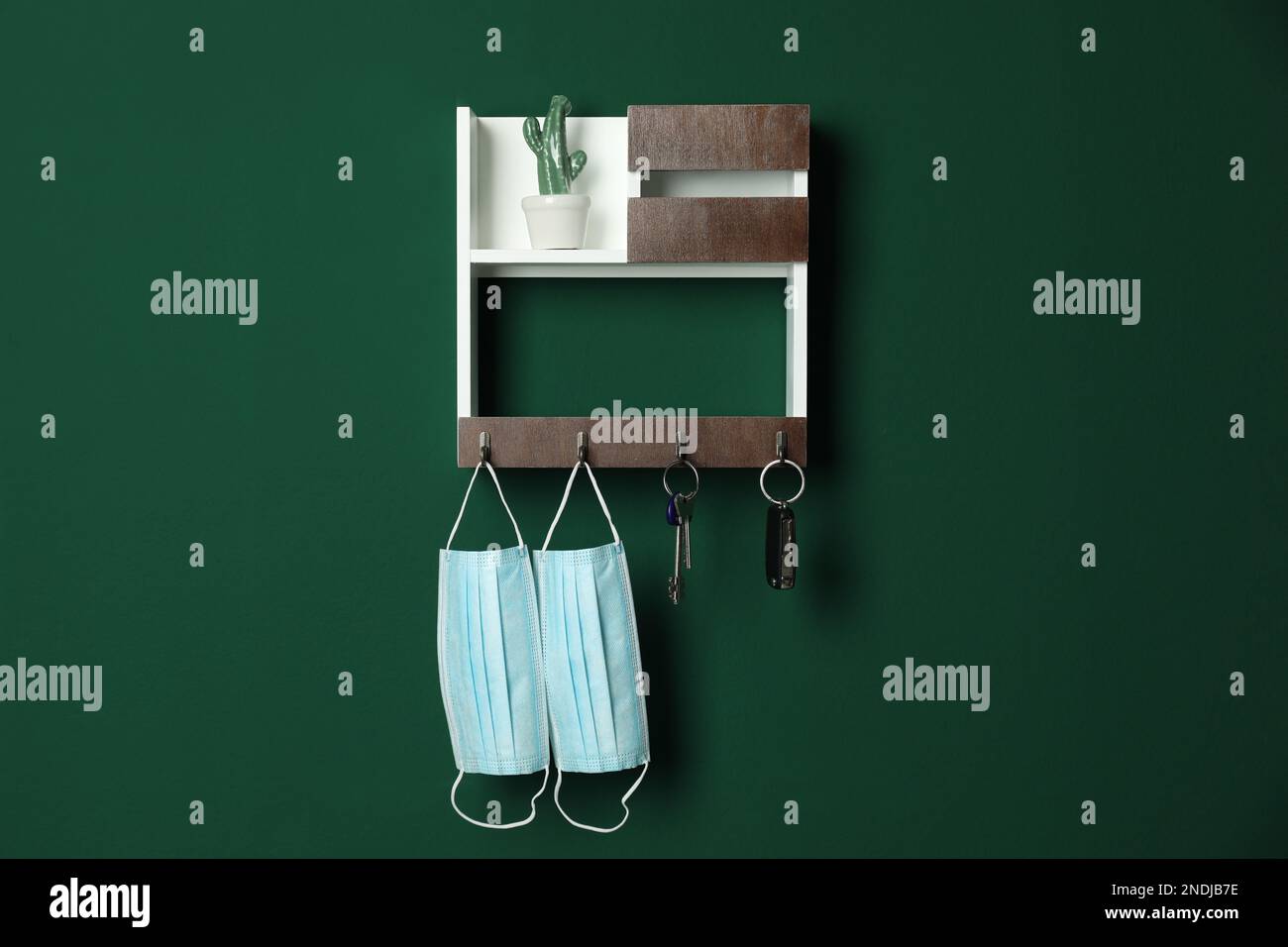 Wooden hanger for keys on green wall Stock Photo - Alamy