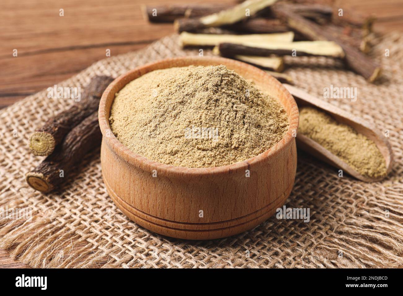 Dried sticks of liquorice root and powder on wooden table, closeup ...