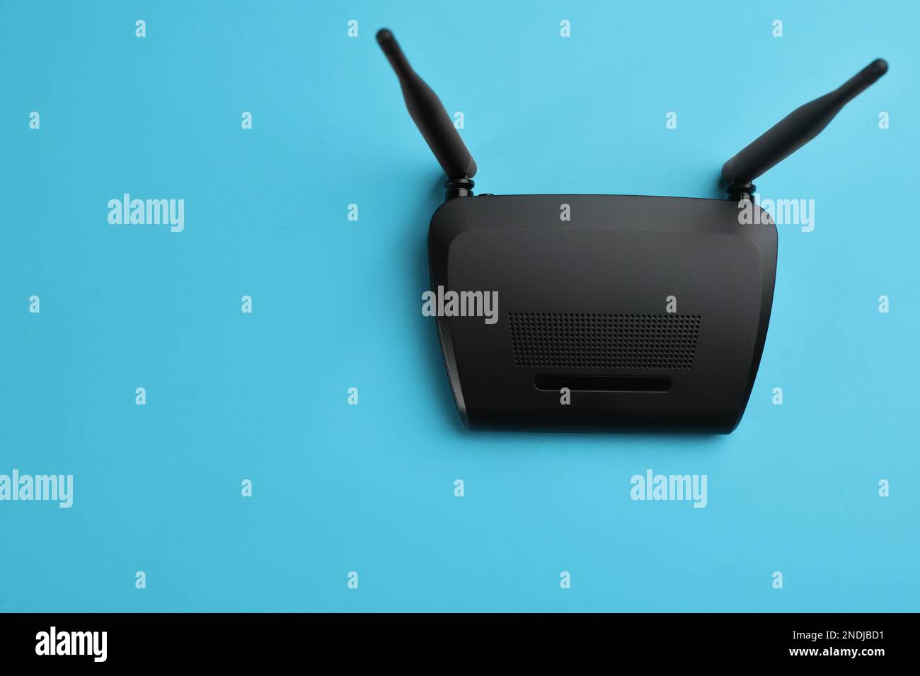 Modern Wi-Fi router on light blue background, top view. Space for text ...
