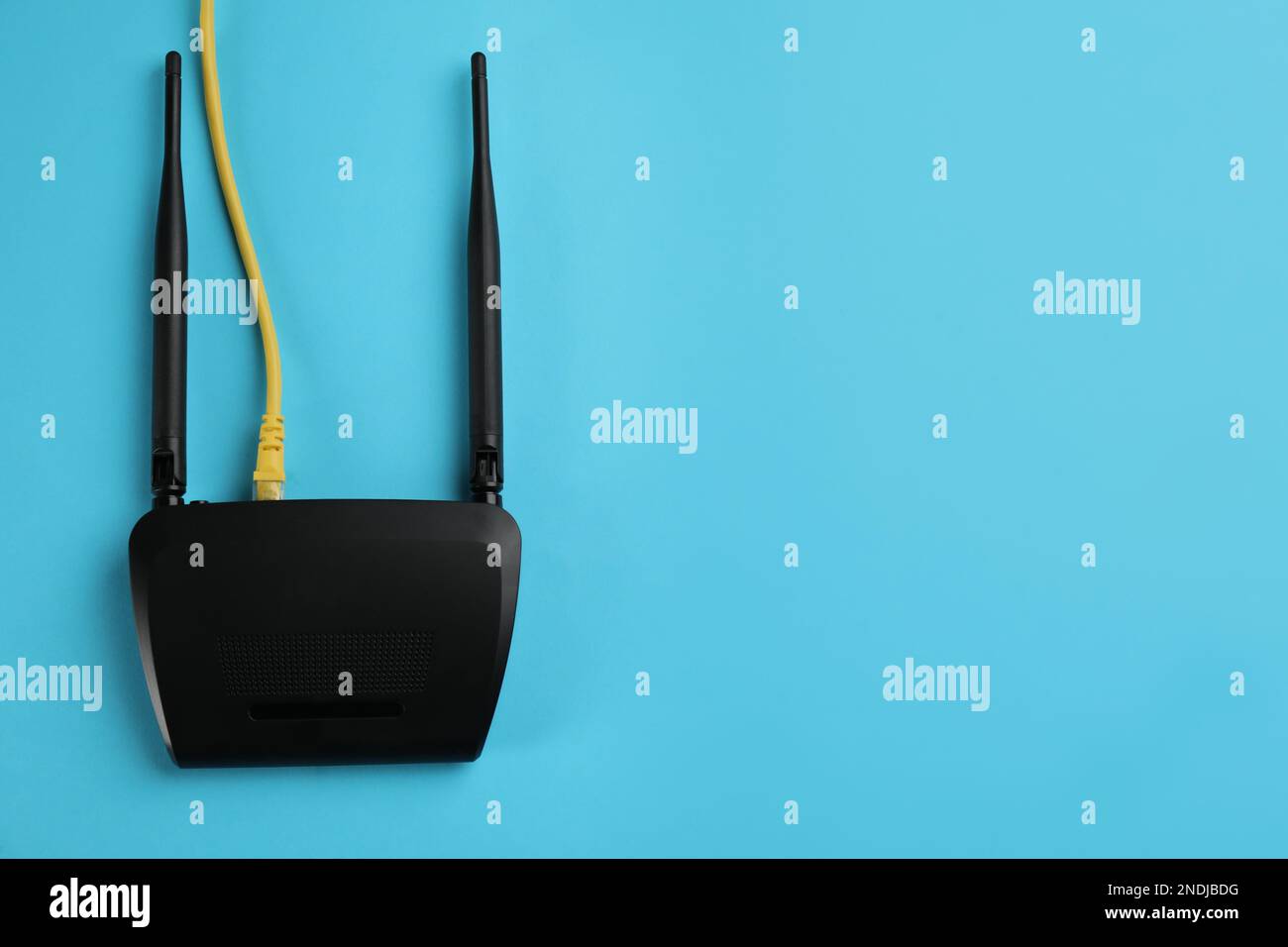 Modern Wi-Fi router on light blue background, top view. Space for text ...