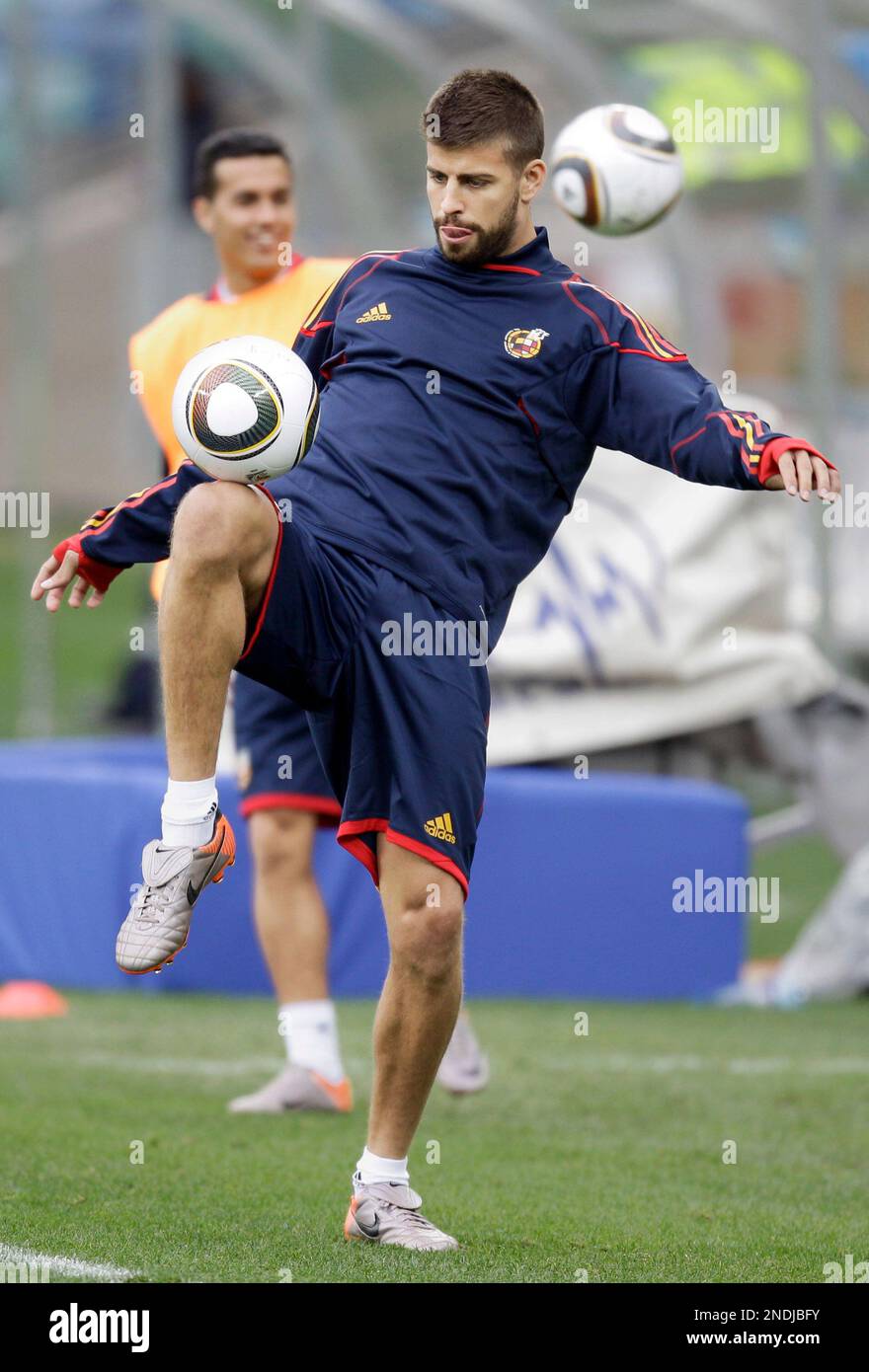 Spain's soccer player Gerard Pique plays with a ball during a team ...