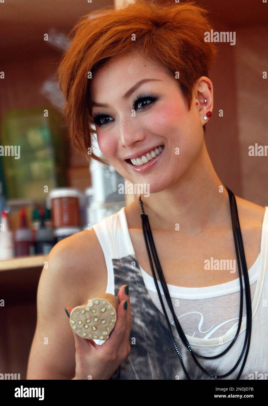 A smiling Hong Kong singer Sammi Cheng holds a handmade soap during an ...
