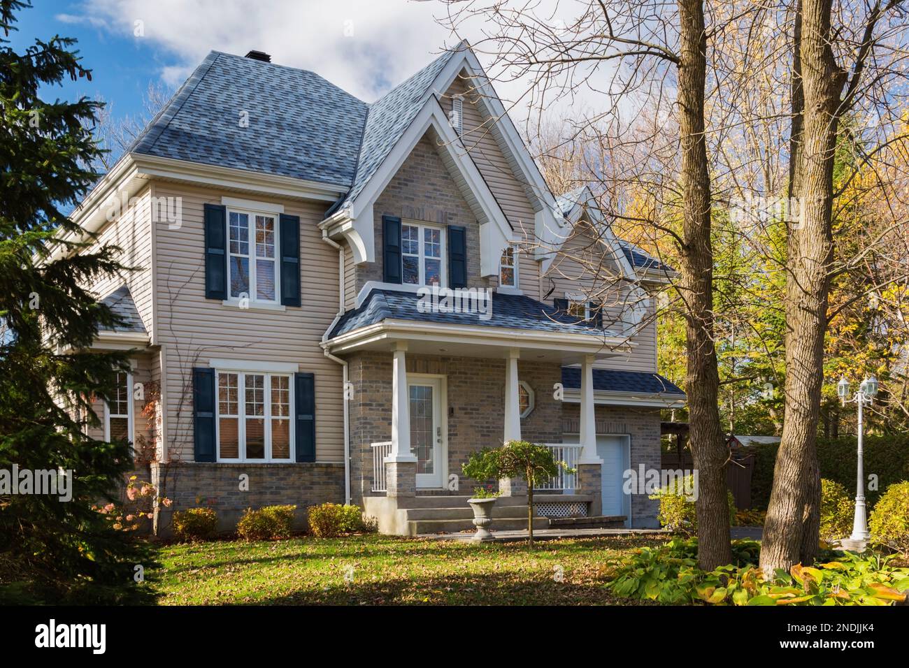 Country tan brick and vinyl cladded cottage style house facade with ...