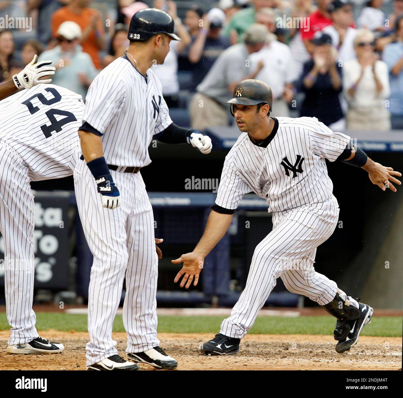 New York Yankees' Robinson Cano (24) and Nick Swisher, center, greet ...