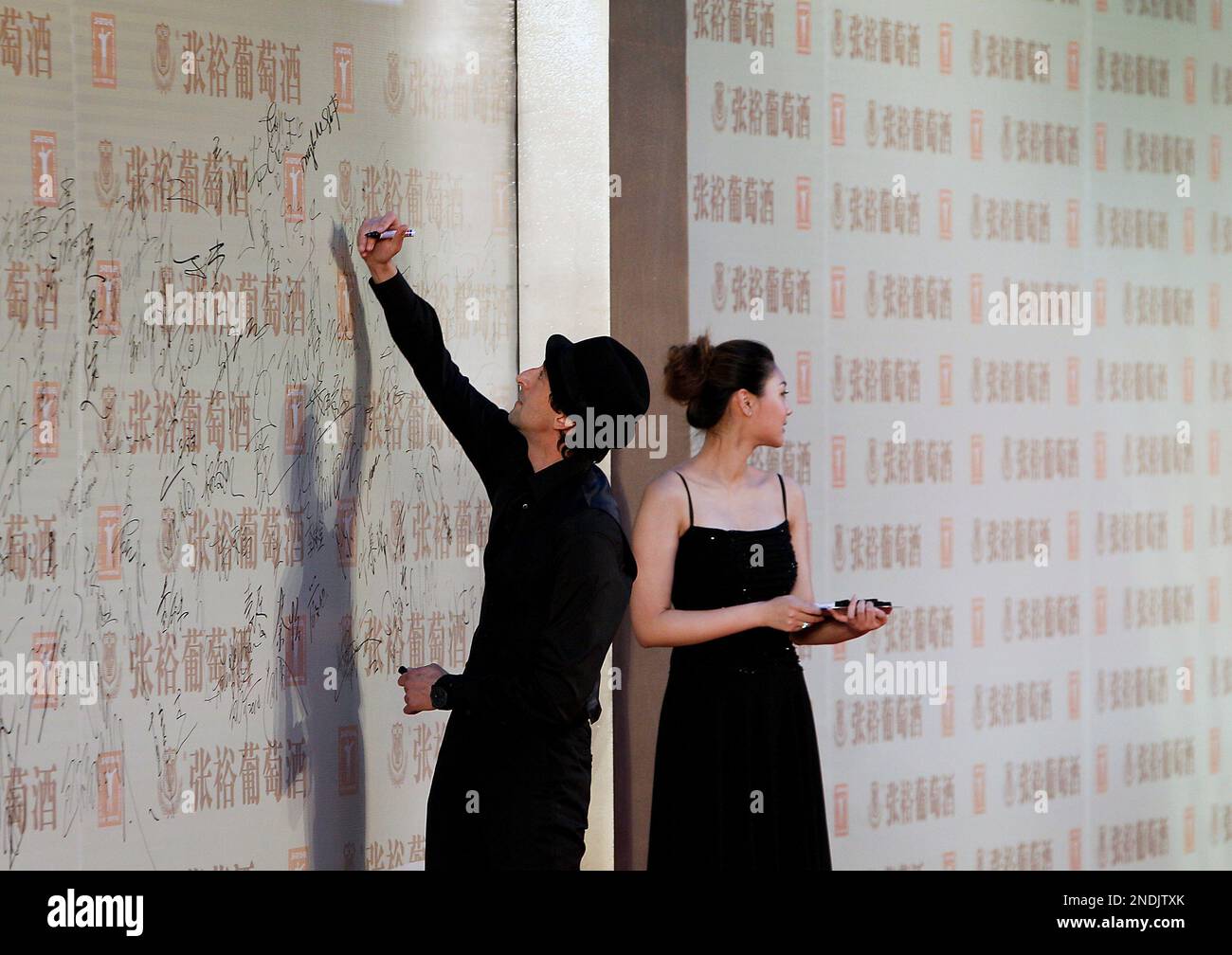 U.S. actor Adrien Brody autographs a board as he arrives, at the ...