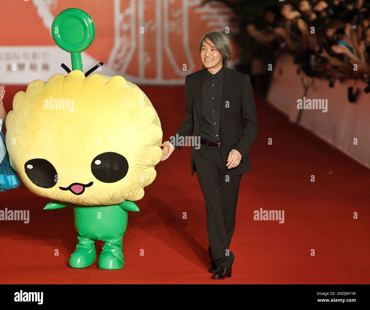 Hong Kong actor Stephen Chow arrives with a movie mascot at the opening ...