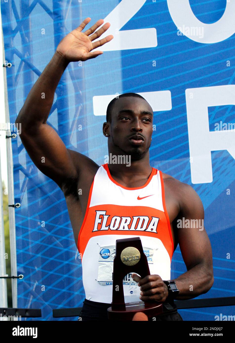 Florida's Jeff Demp holds the trophy after winning the 100 meters with ...