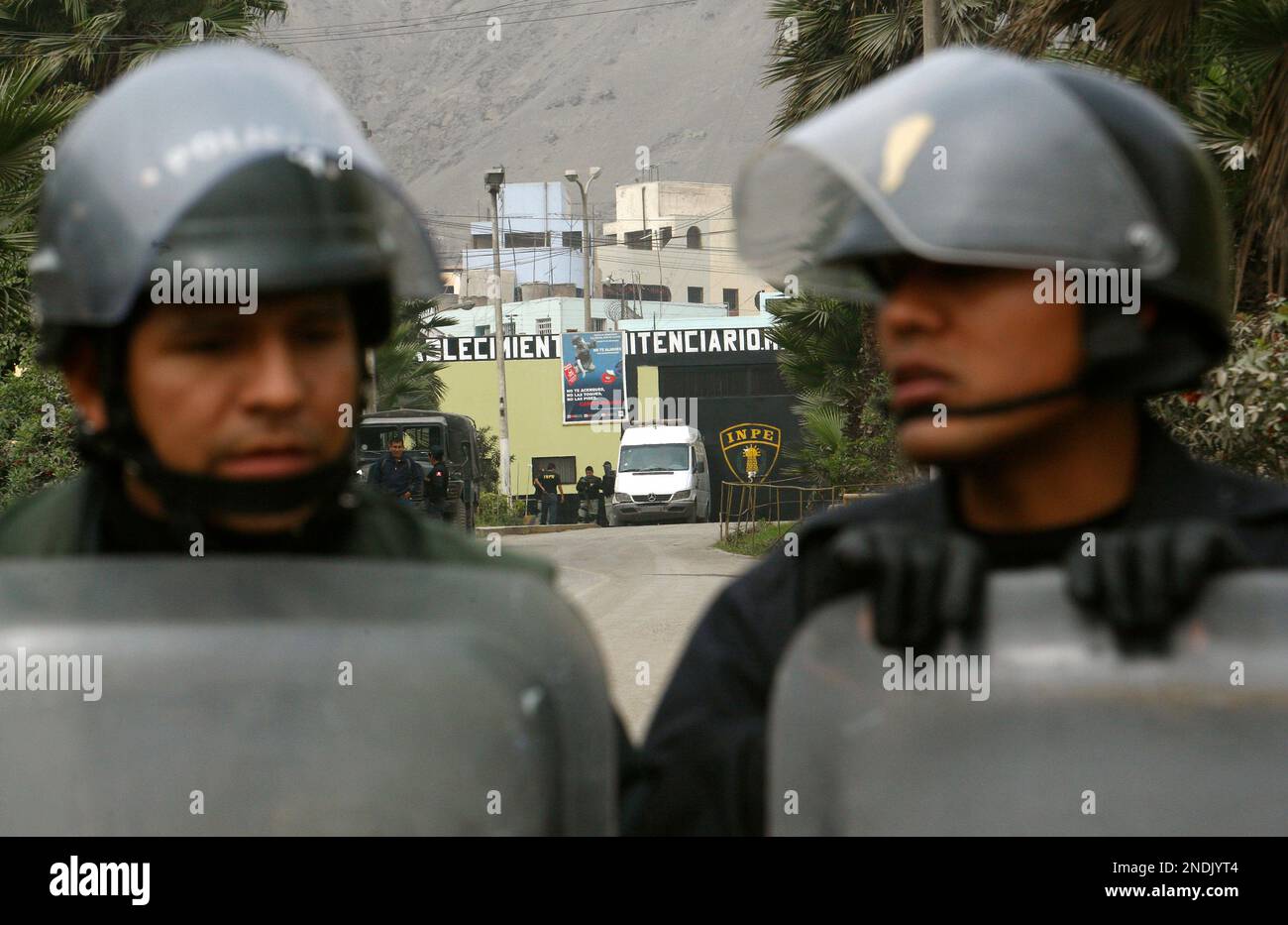 Police officers talk outside the Miguel Castro Castro prison where ...