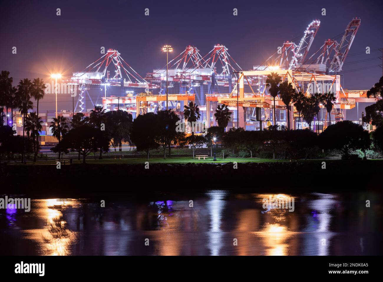 Night time view of container cranes and cargo shipping containers being ...