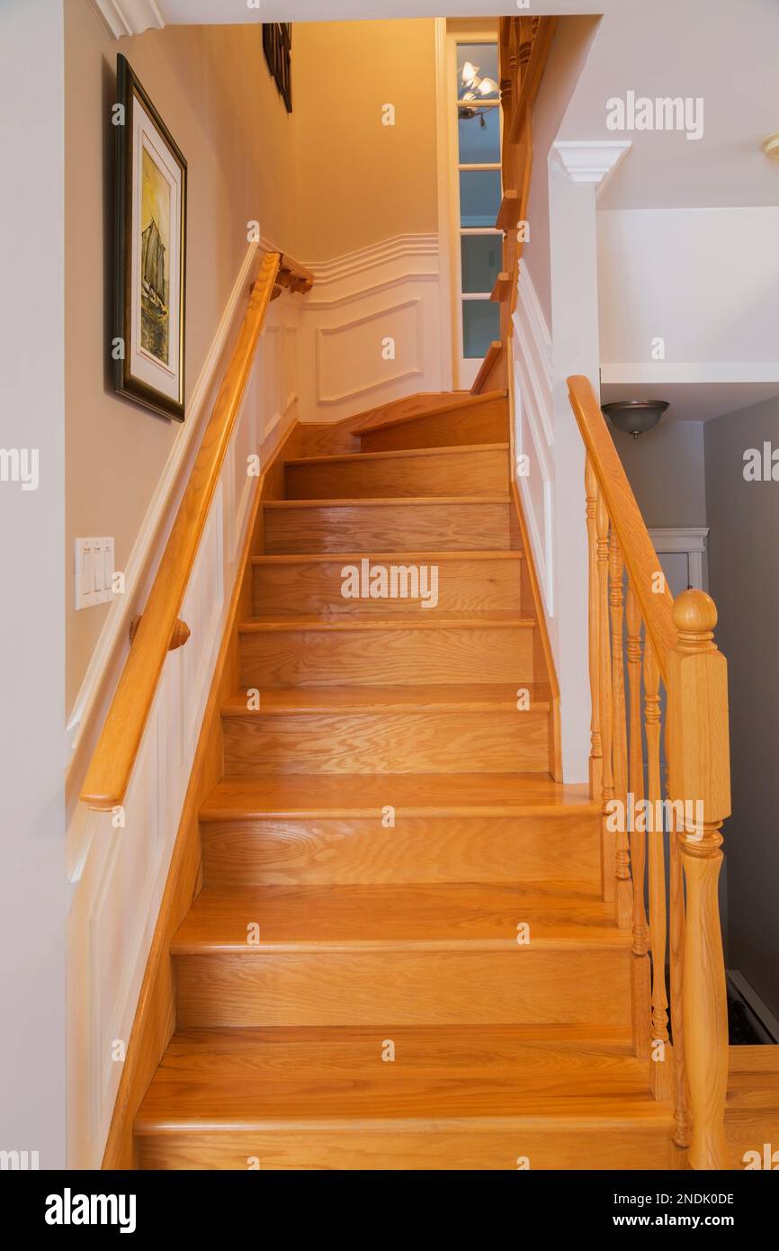 Oak wood staircase leading to upstairs floor inside country style house ...