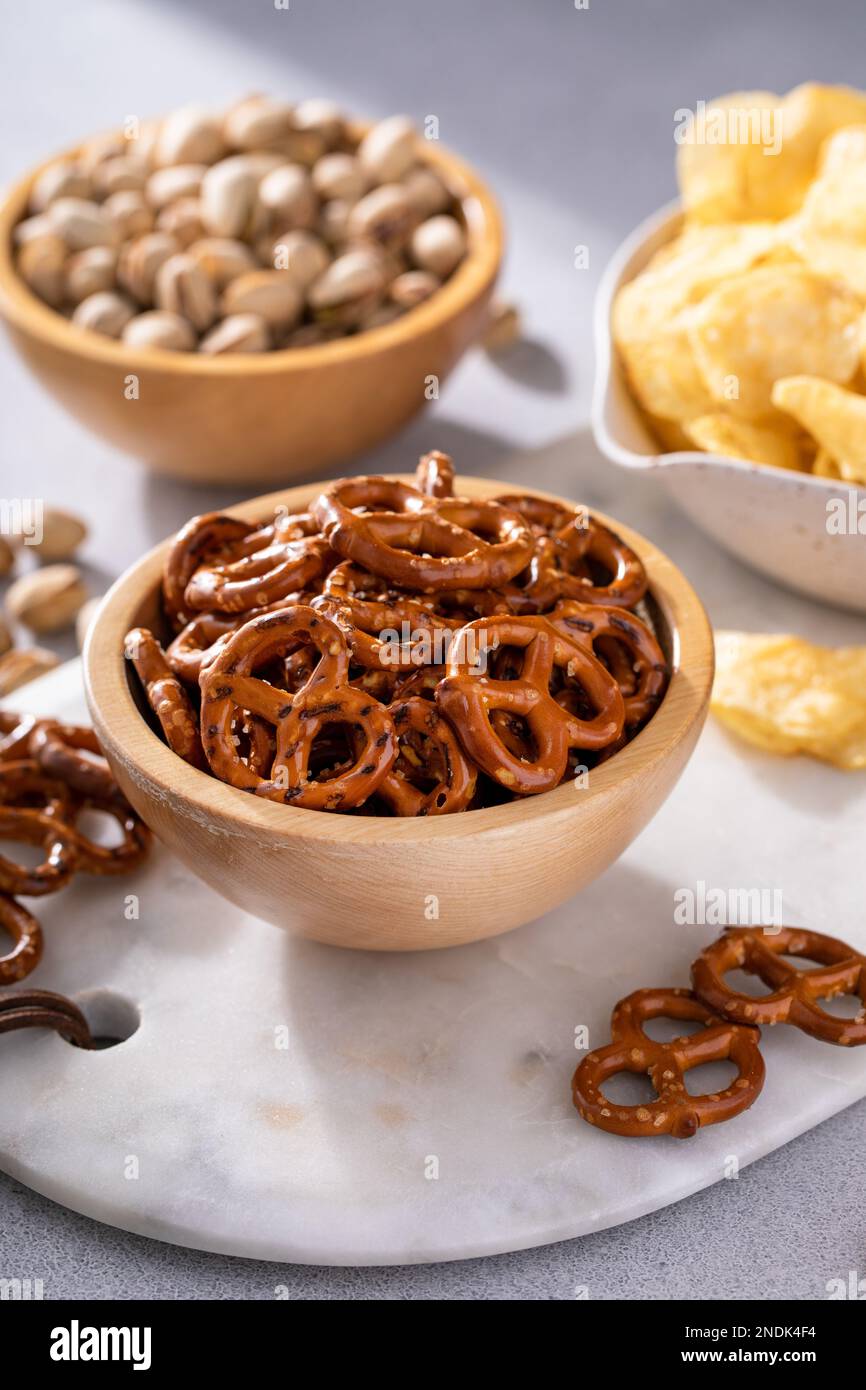 Variety of salty snacks on the table with pretzels, pistachios and ...
