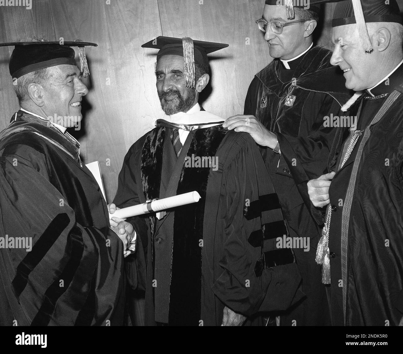 The hood of a doctor of humane letters is placed over the shoulder of ...