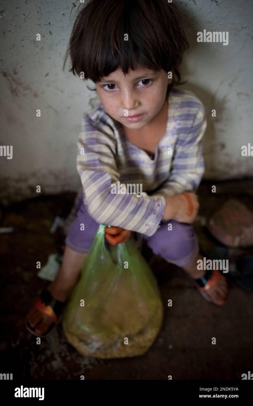 Pakistani child hold a bag of rice at the Sufi shrine Beri Iman food ...