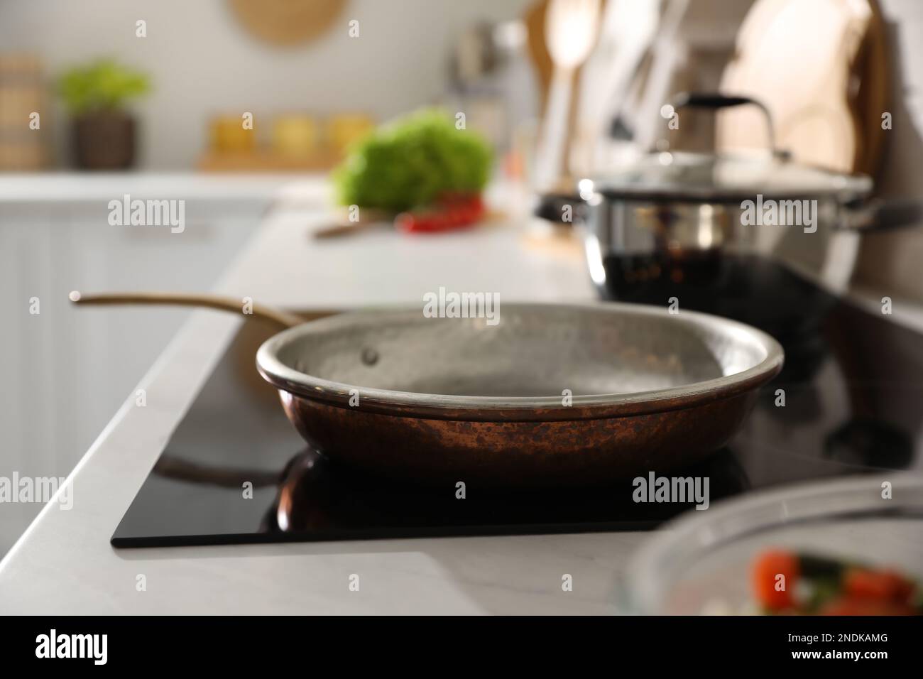 Frying pan on modern cooktop in kitchen Stock Photo - Alamy