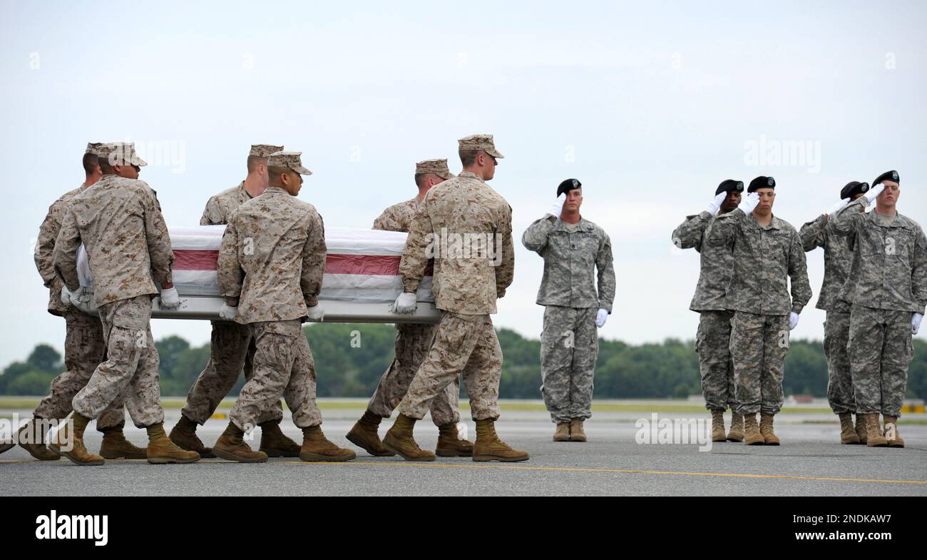 A U.S. Marine carry team carries the transfer case containing the ...