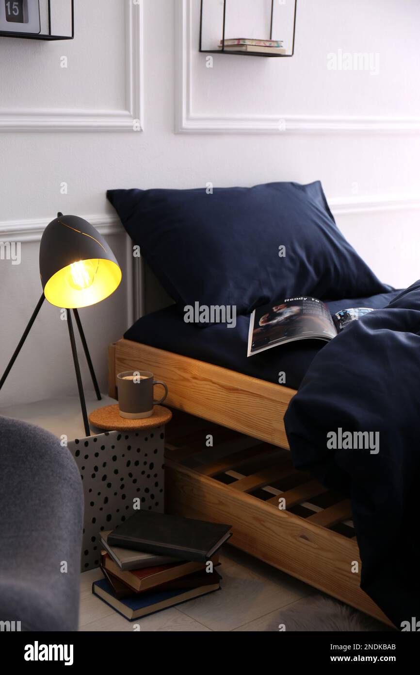 Open magazine on bed with stylish silky linens Stock Photo - Alamy
