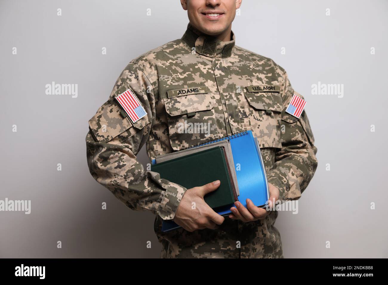 Cadet with books on grey background, closeup. Military education Stock ...