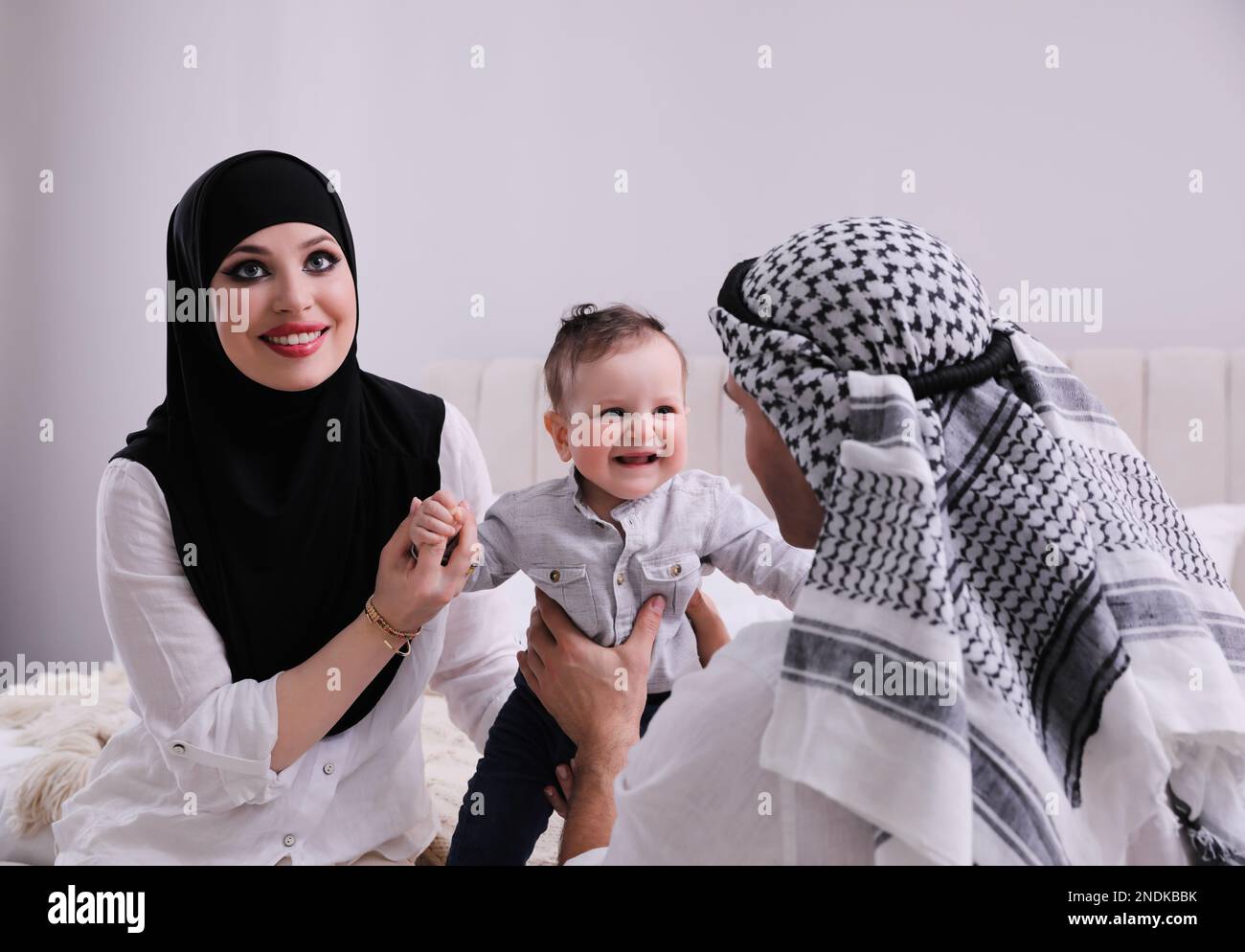 Happy Muslim family with little son in bedroom Stock Photo - Alamy