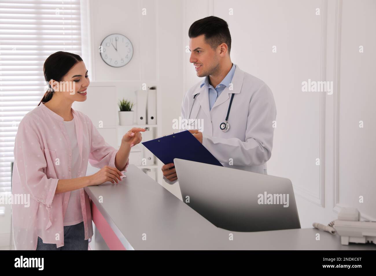 Doctor working with patient at reception in hospital Stock Photo - Alamy