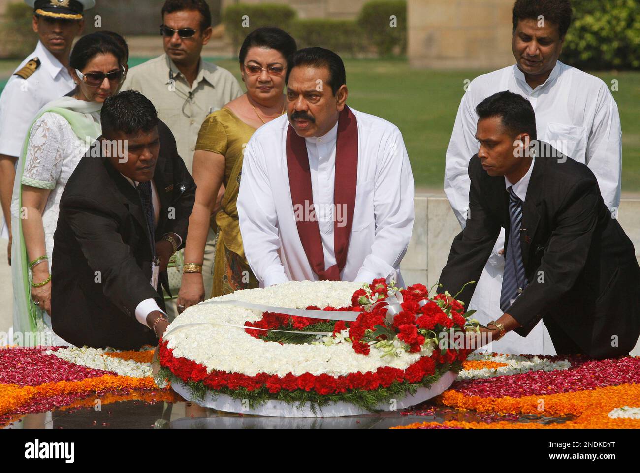 Sri Lankan President Mahinda Rajapaksa, center, pays a floral tribute ...