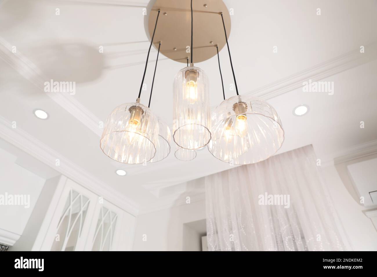 Stylish pendant lamp with light bulbs on ceiling in modern room Stock ...