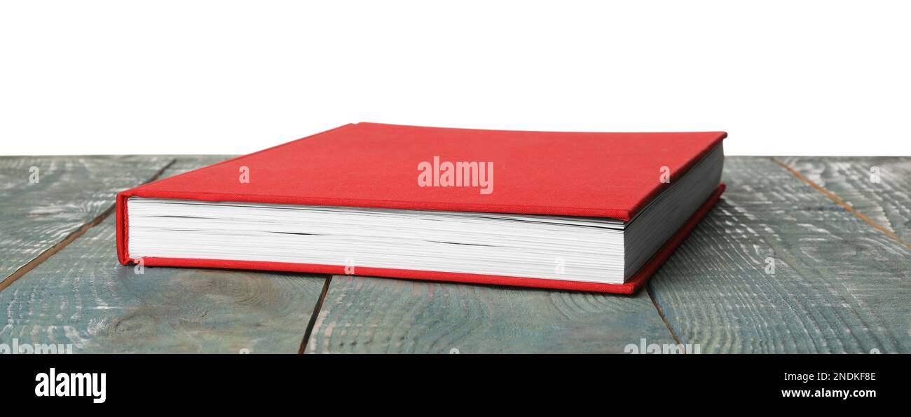 Book with red cover on wooden table against white background Stock ...