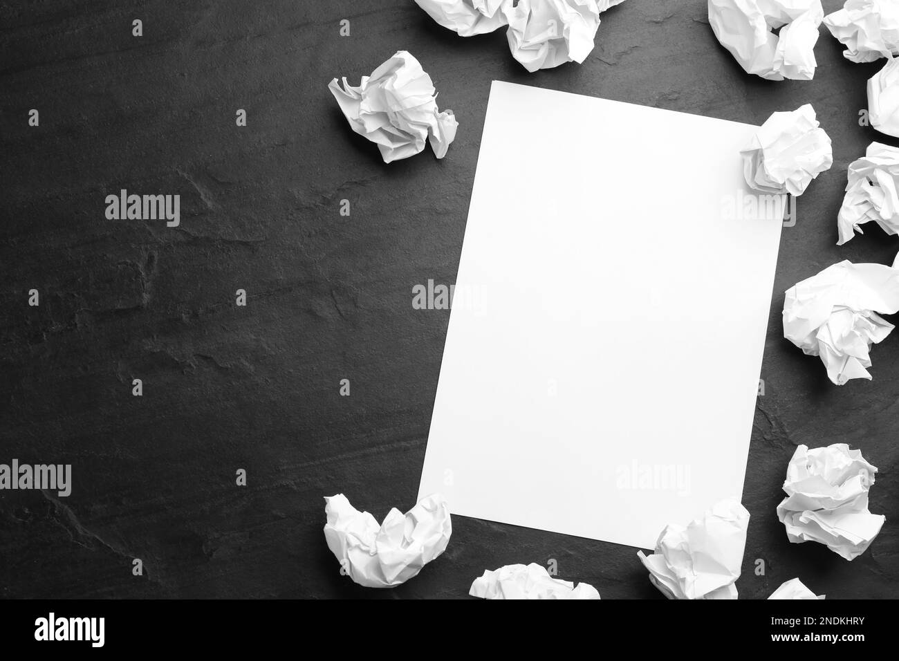 Blank sheet and crumpled paper balls on black background, flat lay ...