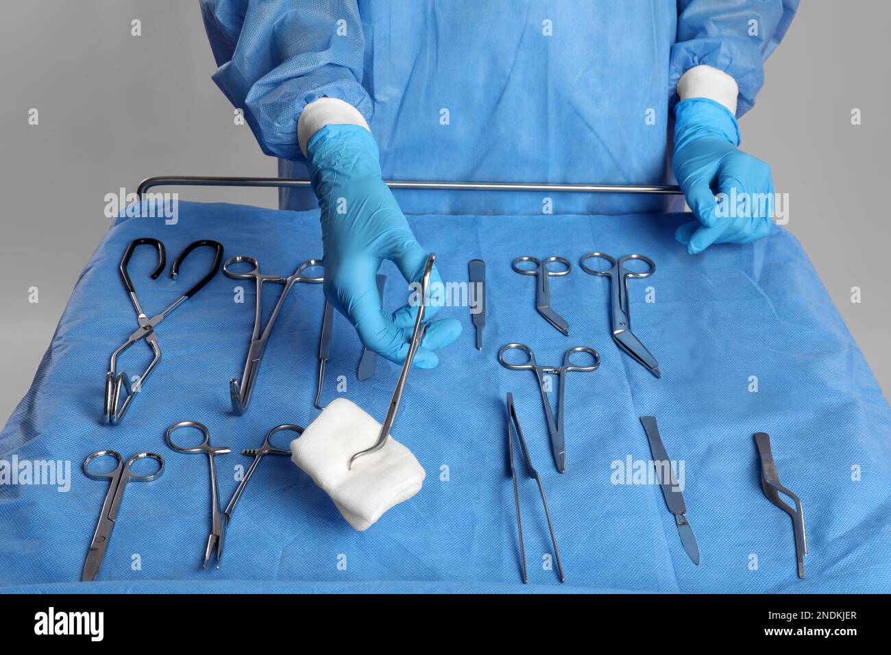 Doctor holding medical forceps with pad near table of different ...