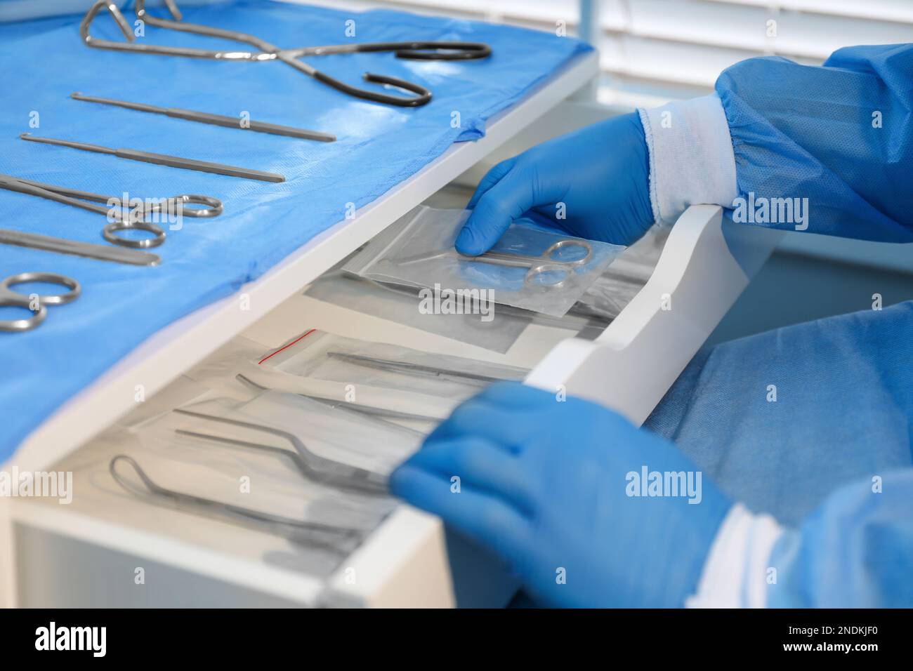 Doctor putting Pott's scissors into drawer indoors, closeup. Table with ...