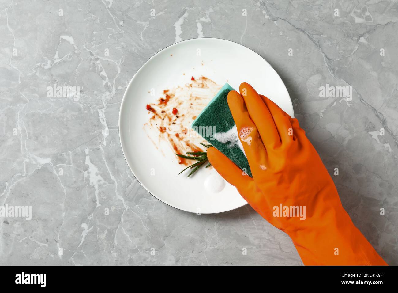 Woman washing dirty plate at grey marble table, top view Stock Photo ...